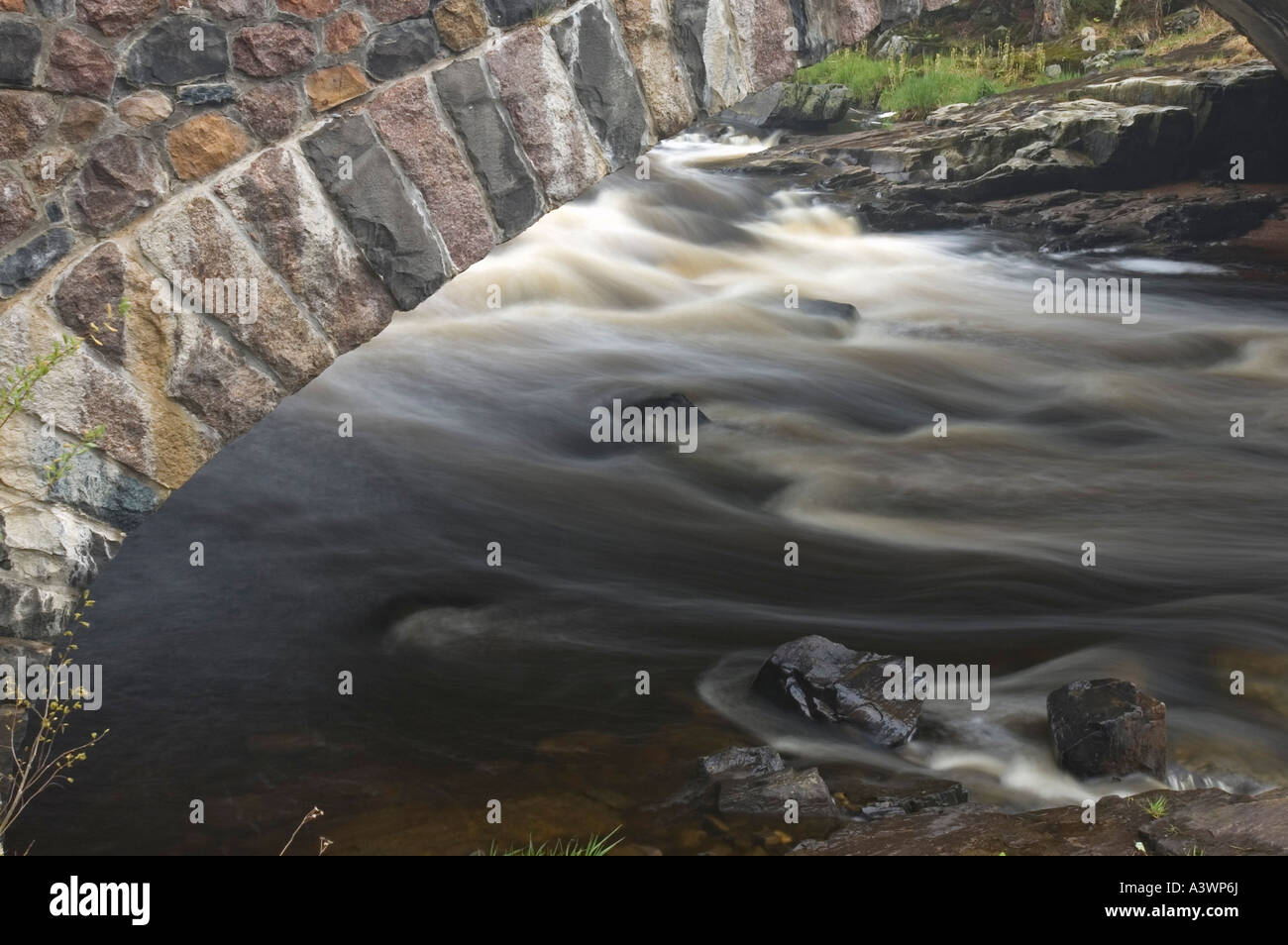 A stone bridge crosses the Eau Claire River at the Dells of the Eau ...