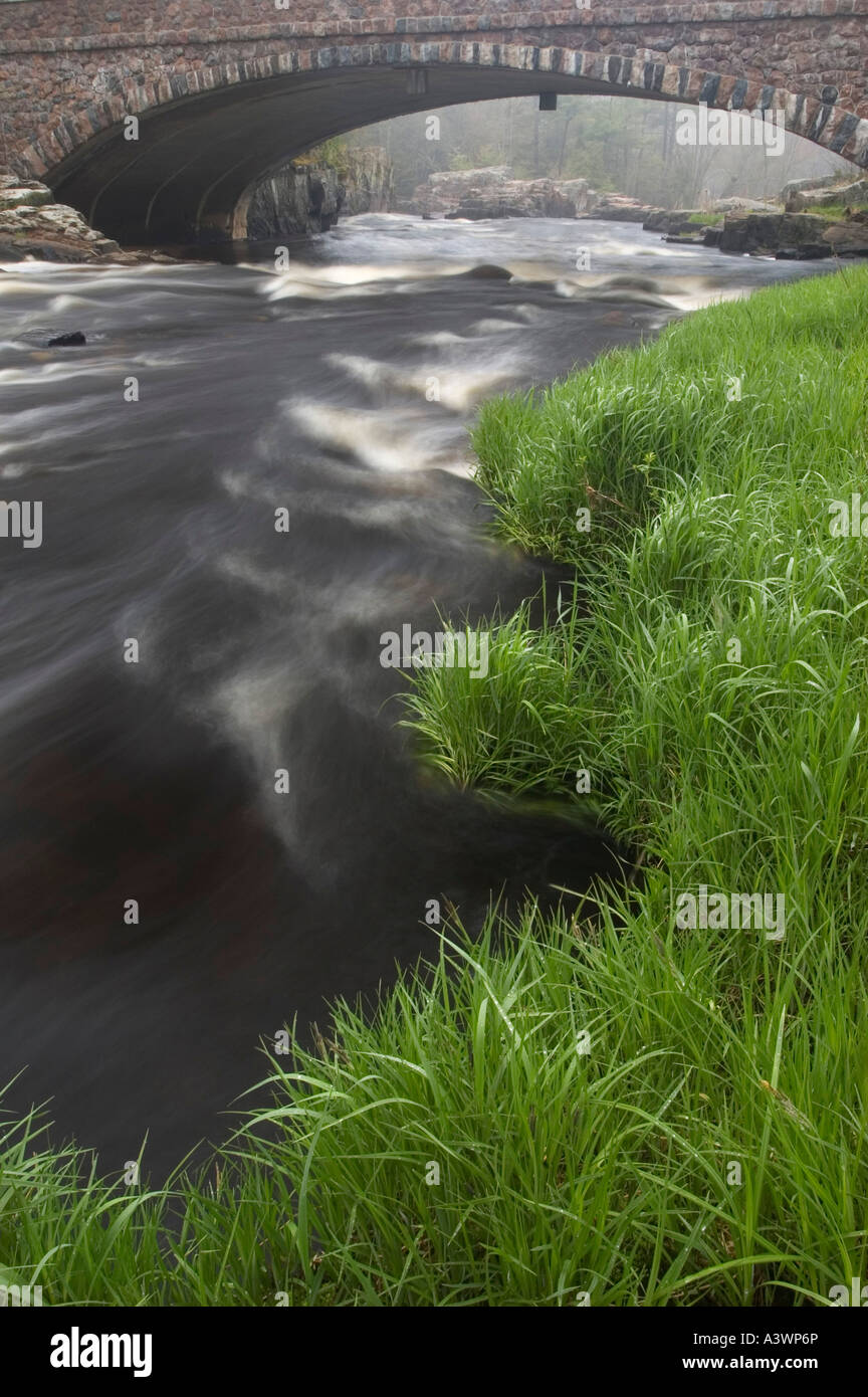 A stone bridge crosses the Eau Claire River at the Dells of the Eau ...