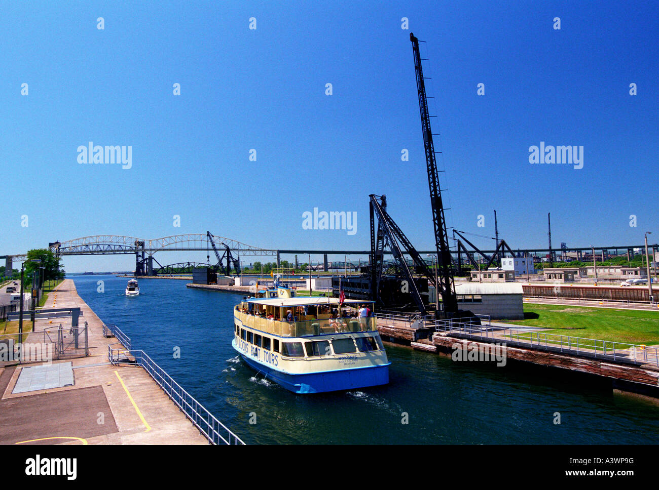 A TOUR BOAT AND A YACHT MOVE OUT OF THE SOO LOCKS ON THE SAINT MARYS ...