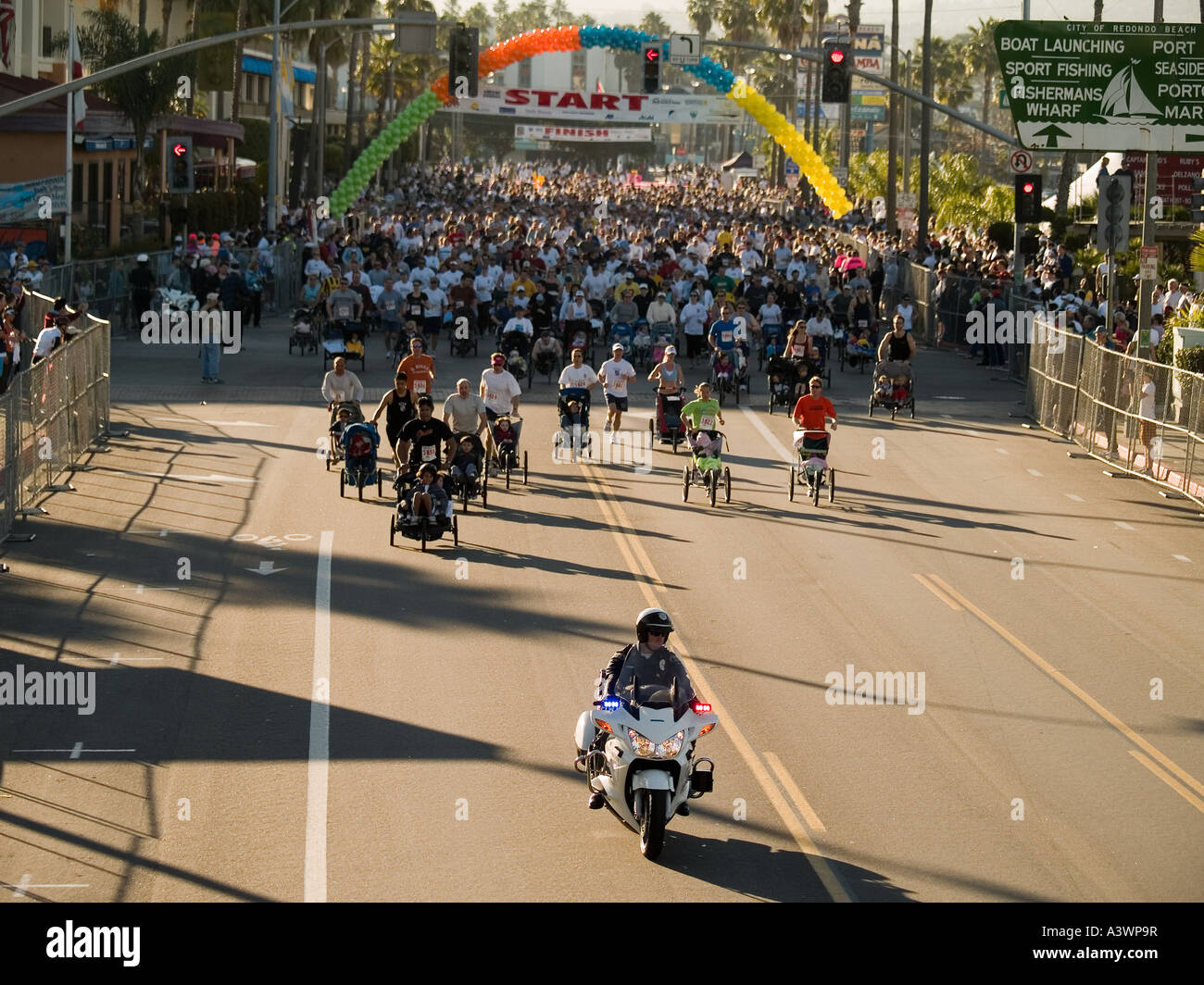 Motorcycle patrolman leads the start of the baby buggy competition ...