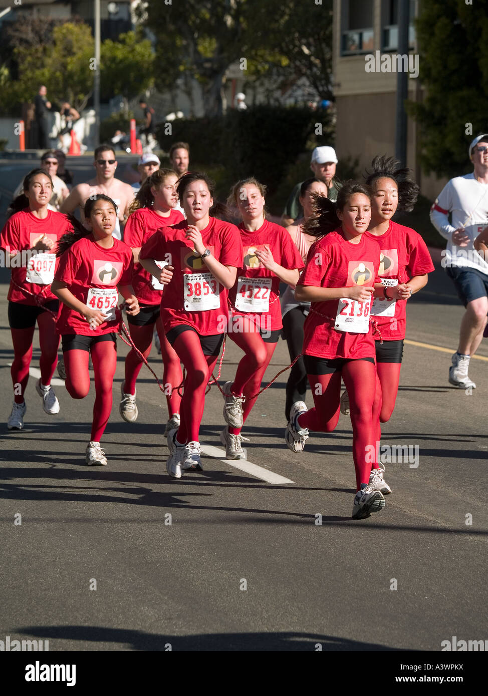 Seven teen girls all dressed in red run towards finish line in ...