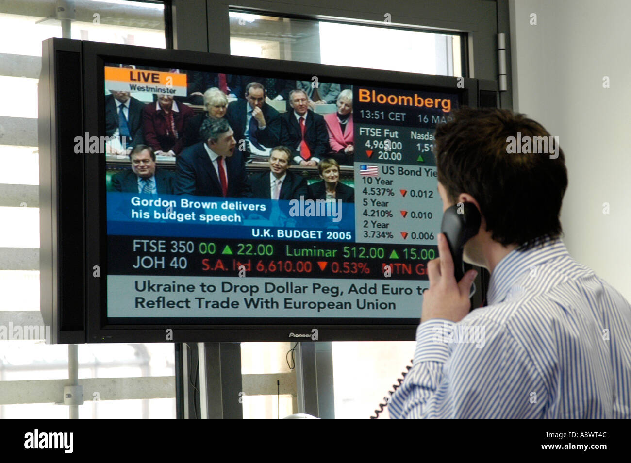 Currency trader watching Bloomberg business channel, London England ...