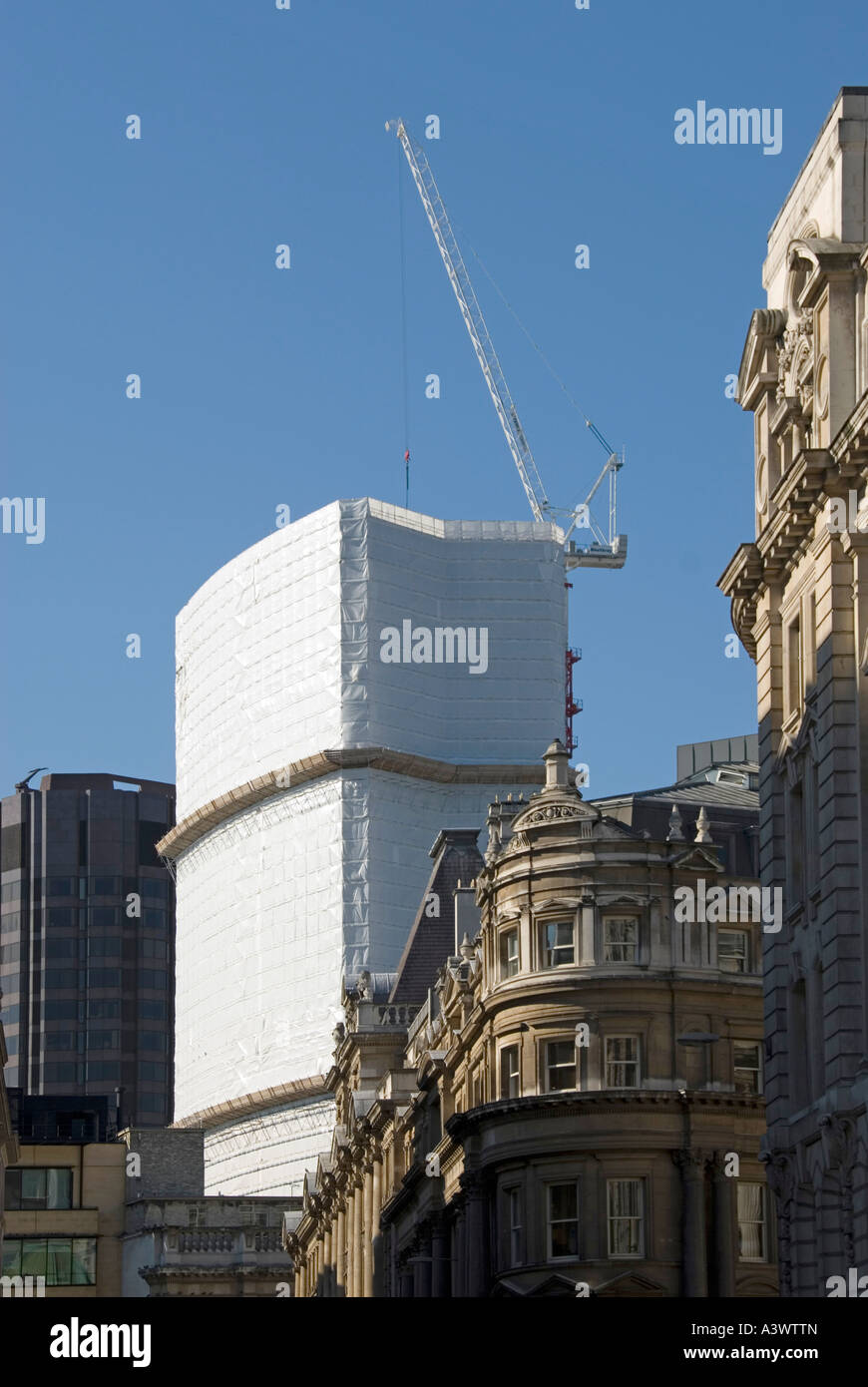 Tall office block & scaffolding wrapped in cocoon of white plastic ...
