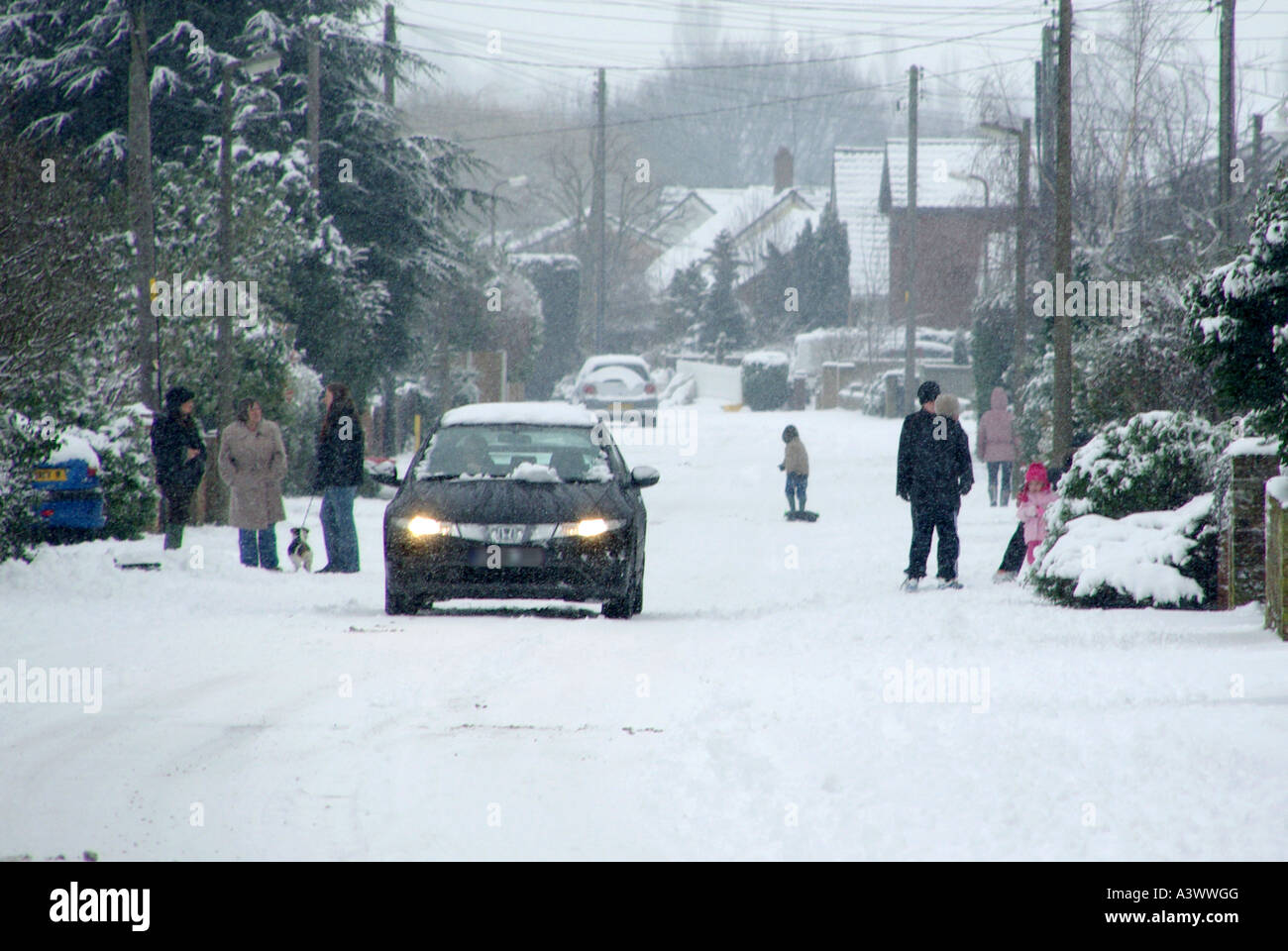 Village winter street scene with snow falling kids playing outdoors ...