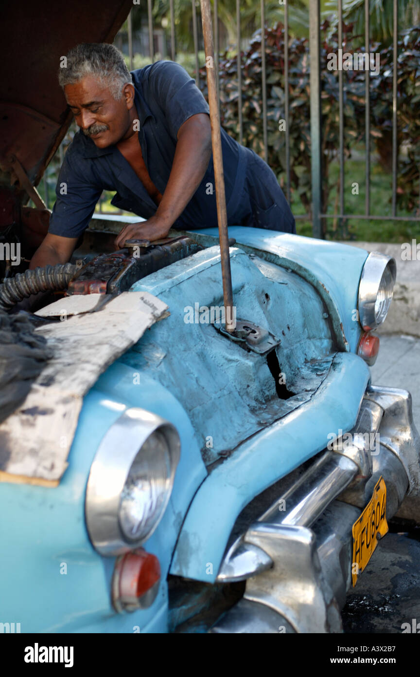A mechanic fixes an old car on the crumbling streets of Old Havana in ...