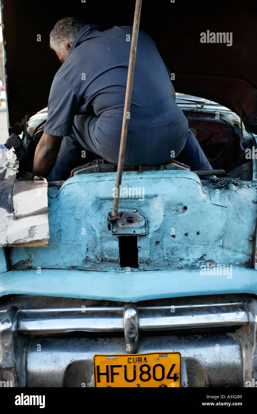 A mechanic fixes an old car on the crumbling streets of Old Havana in ...