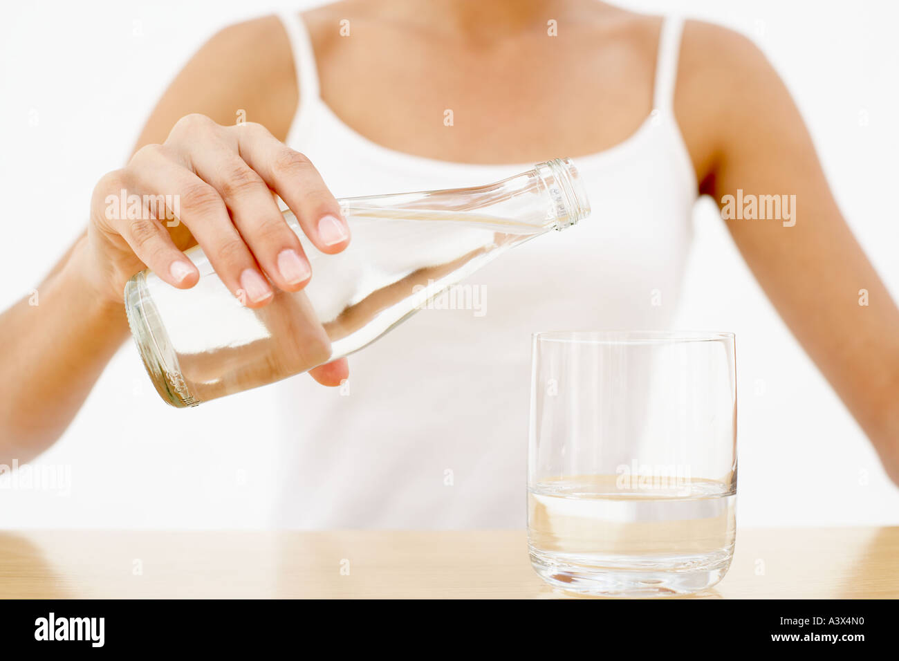 Young woman pouring water into a glass Stock Photo - Alamy