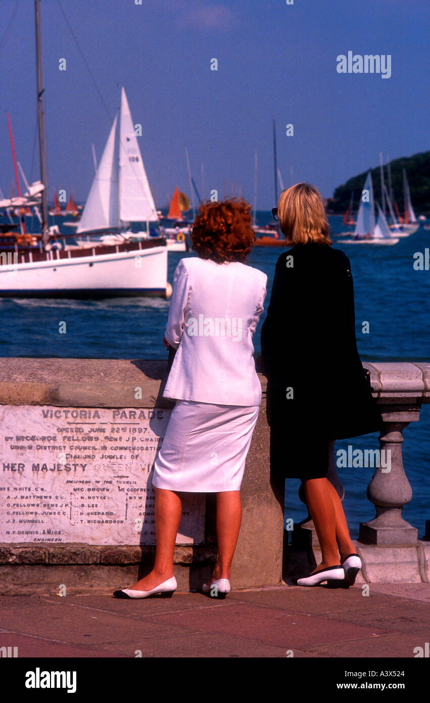 Women spectators in skirt suits watch yacht racing Cowes Isle of Wight ...