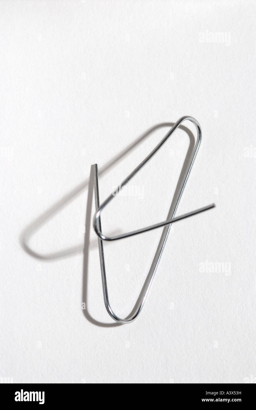 Bent and twisted paperclip Stock Photo - Alamy