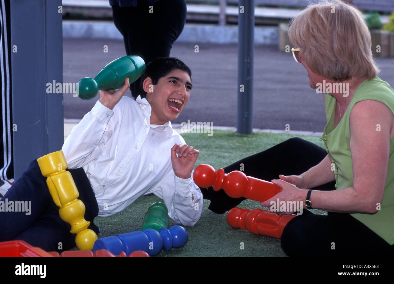 Autistic boy having fun with carer at a special school, London, UK ...