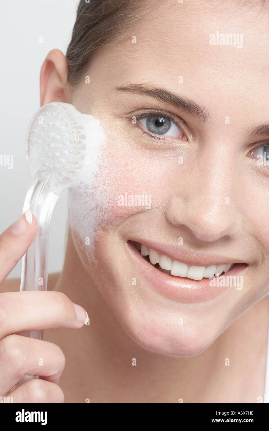 Female scrubbing face with brush hi-res stock photography and images ...