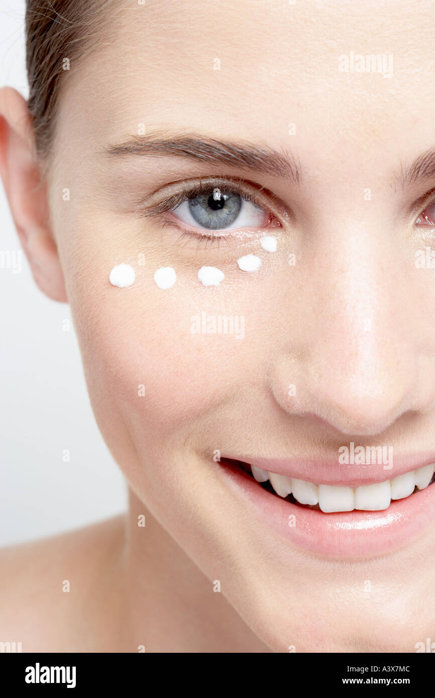 Young woman with cream under her eye Stock Photo - Alamy