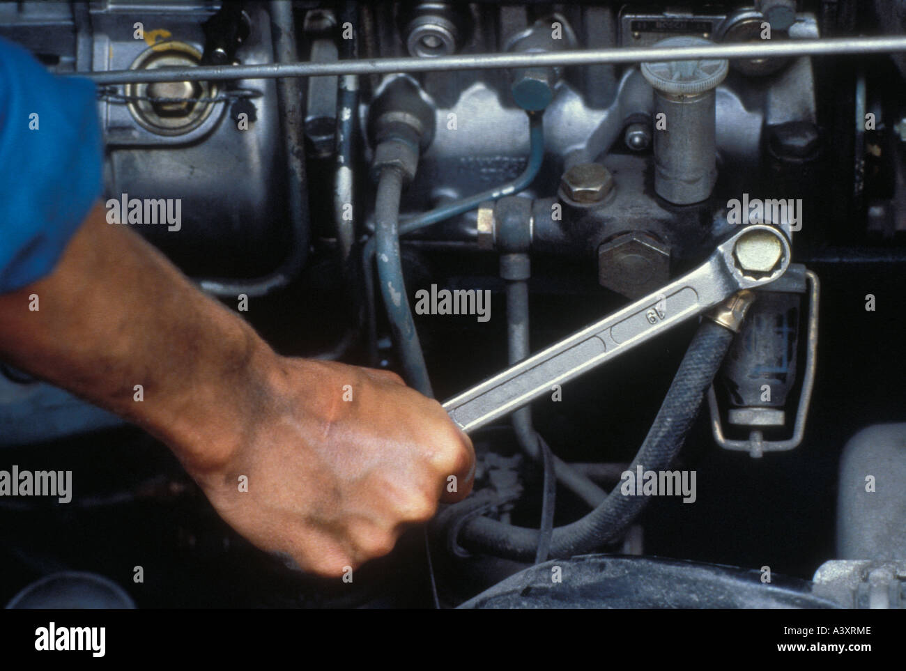 Mechanic with a wrench repairs a diesel engine Stock Photo - Alamy