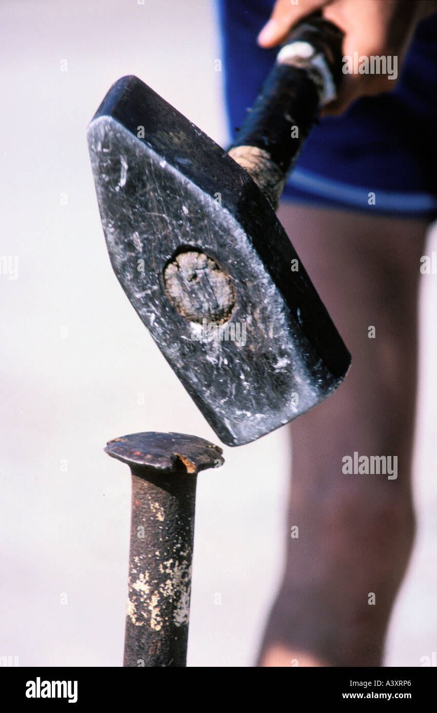 Circus worker hammers down one of the spikes that anchor the tent Stock ...