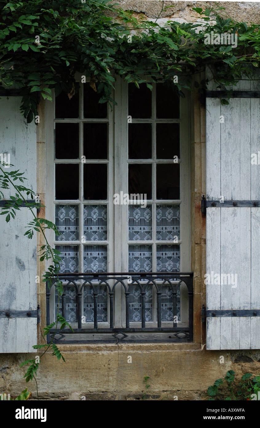 french window with wooden shutters and iron grill with wisteria Stock ...