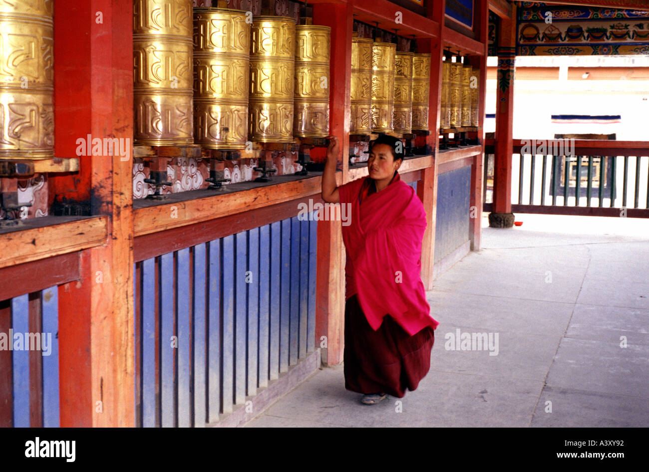 Buddhist devotee spinning prayer wheels at Gong Tang pagoda in Labrang ...