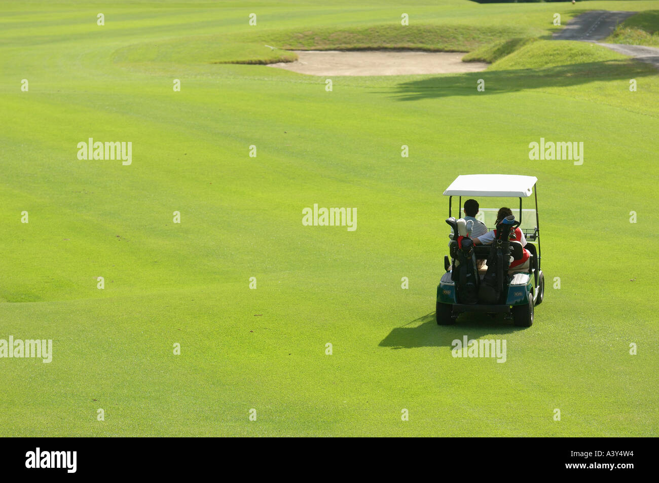 Couple Driving a Golf Cart on a Golf Course Stock Photo - Alamy