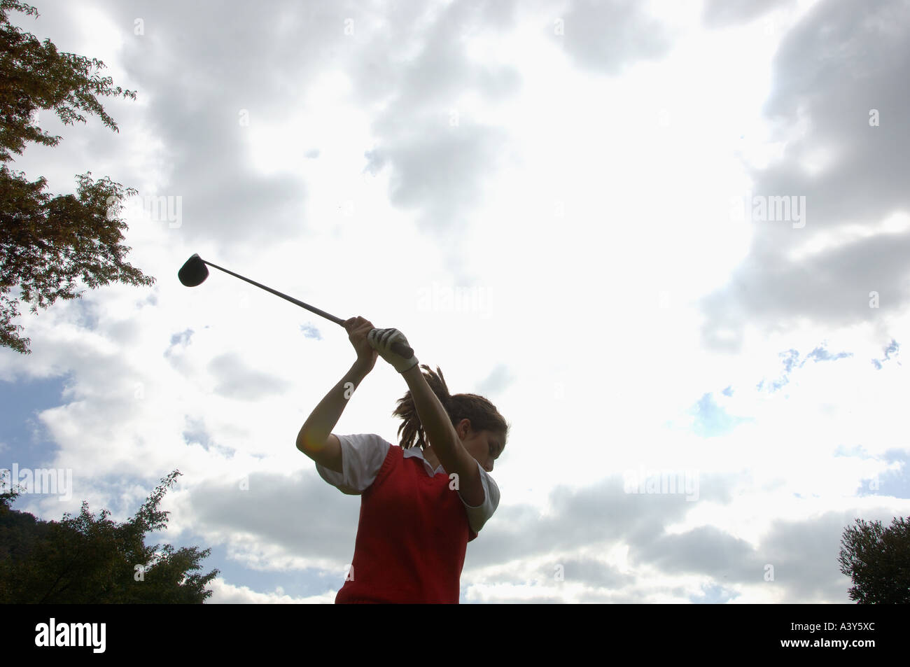 A woman in action of the backswing with a golf club Stock Photo - Alamy