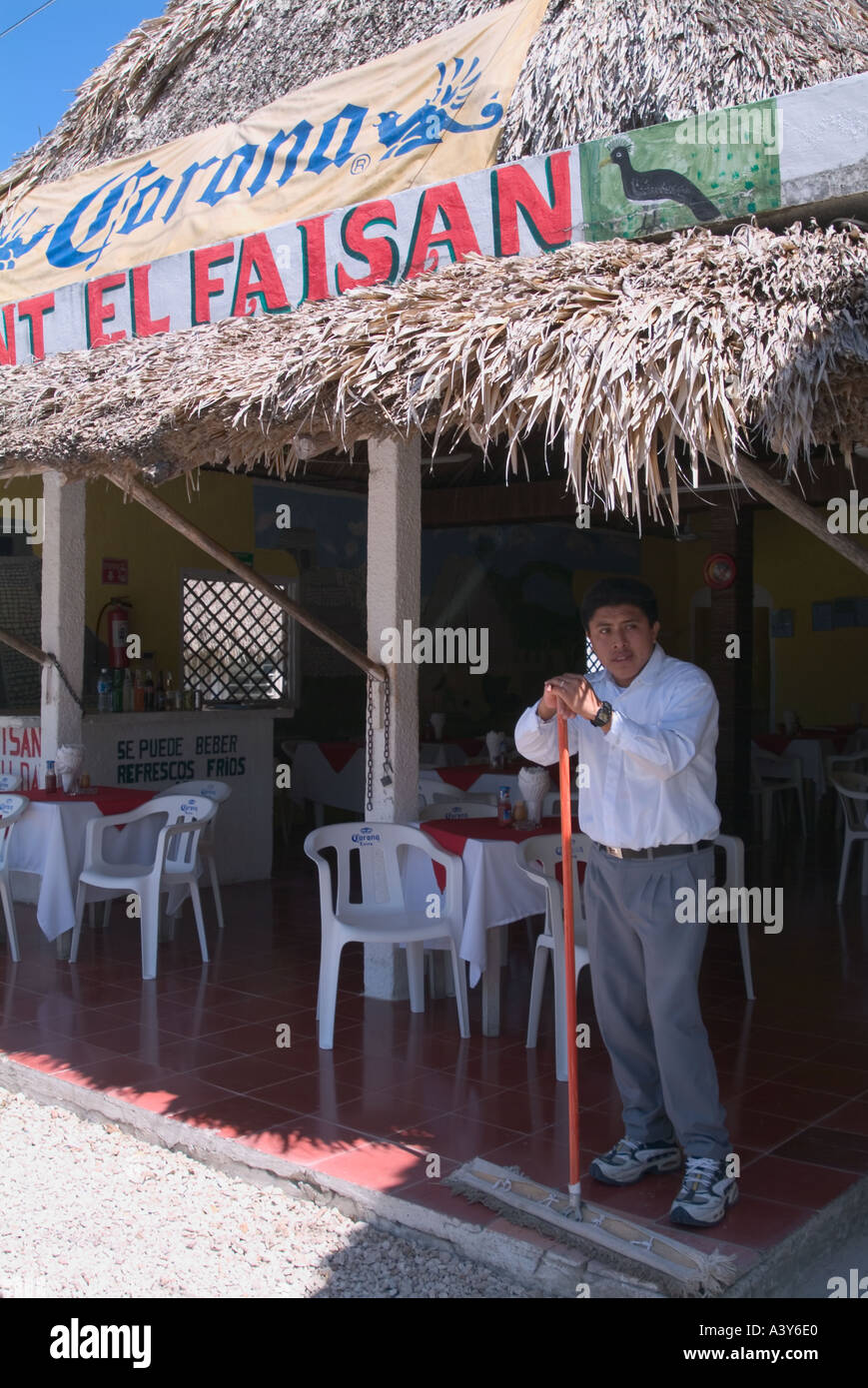 Portrait Mexican waiter with broom standing in front of restaurant ...