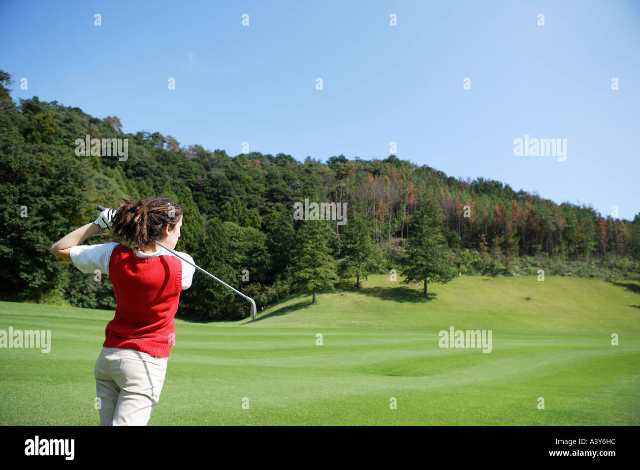 Rear view of a female golfer in action Stock Photo - Alamy