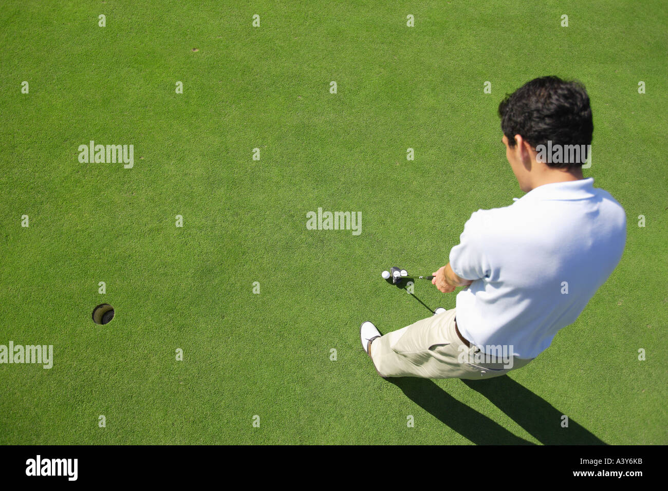 Male golfer making a putt Stock Photo - Alamy
