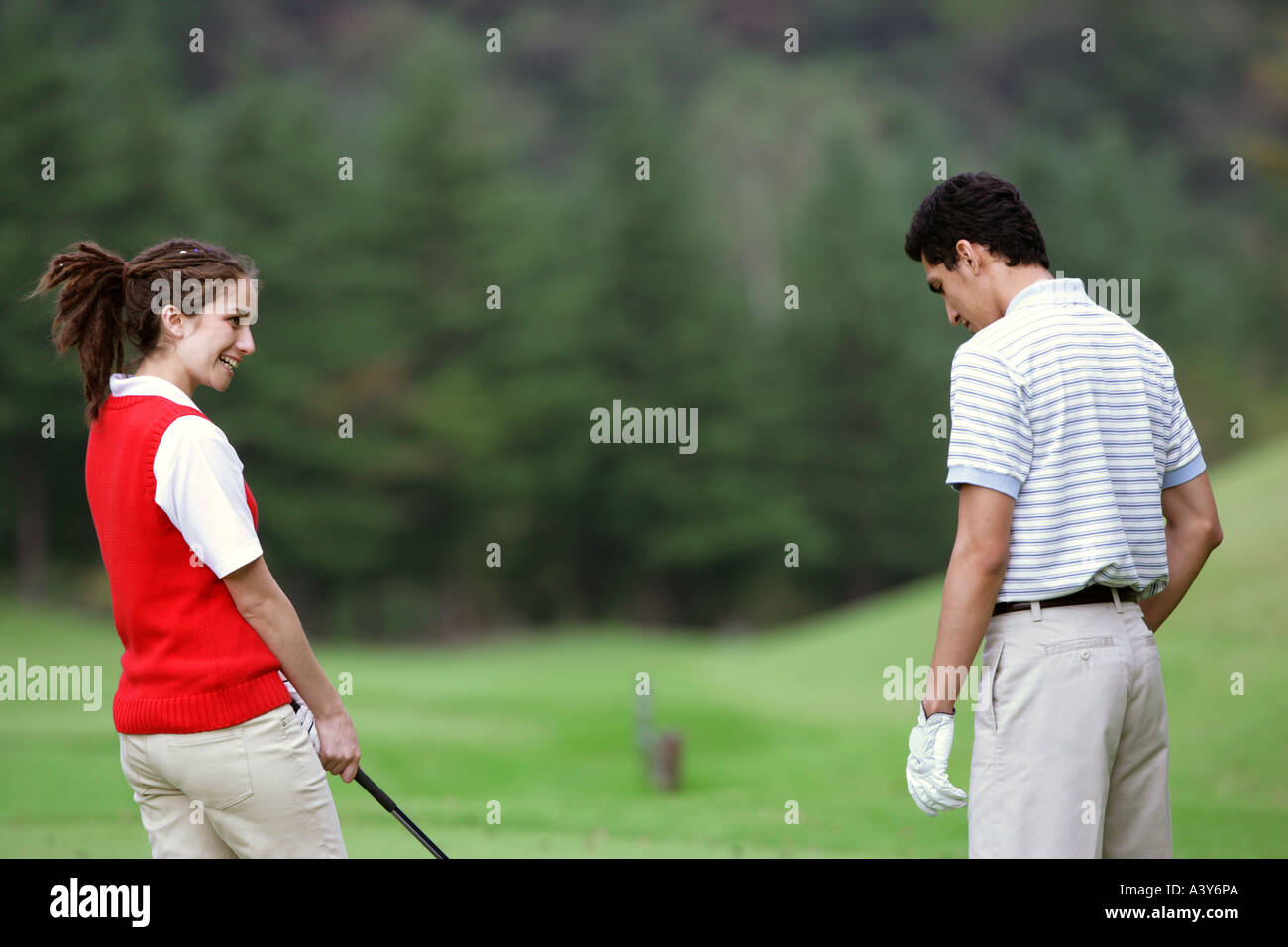 Side view of a couple chatting on the golf course Stock Photo - Alamy
