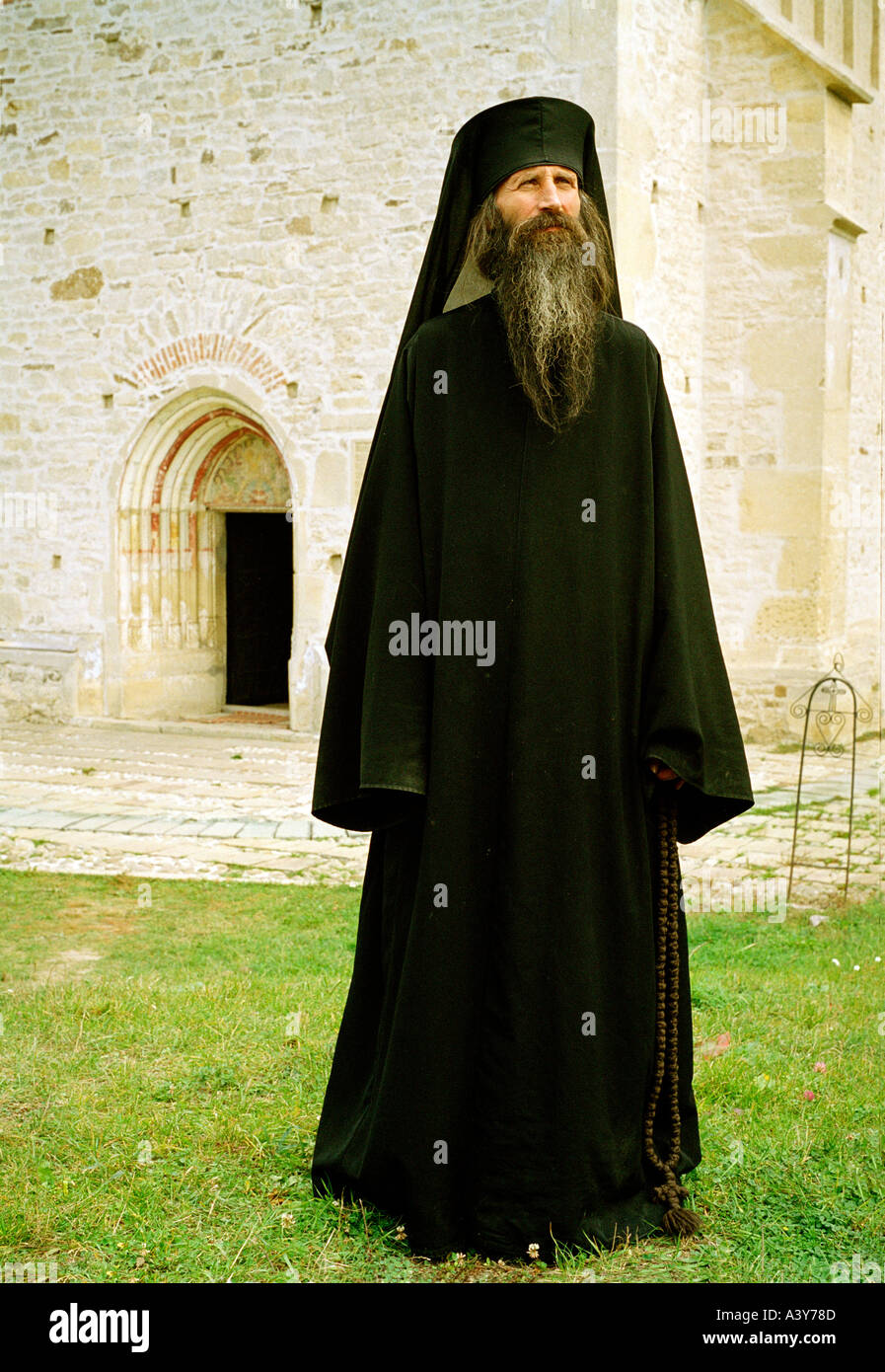 Monk outside a monastery church near Gura Homorului Romania. The ...