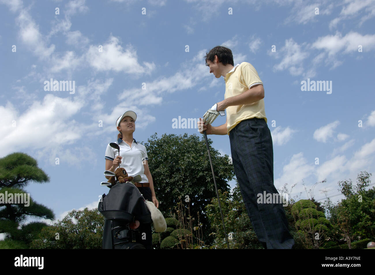 Man and a woman chatting on a the tee ground Stock Photo - Alamy