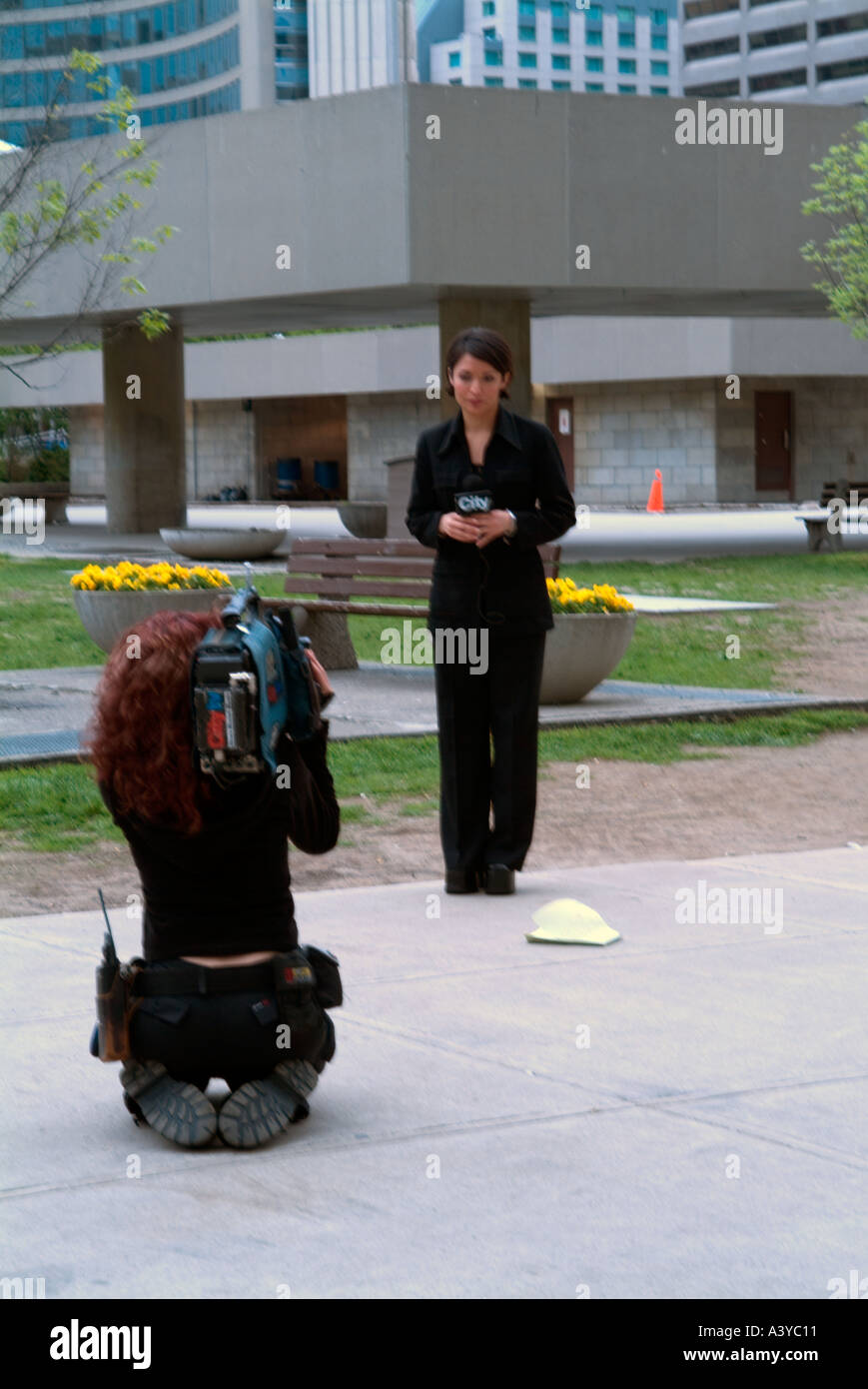 Reportage news camera person female reporter taping downtown Toronto ...