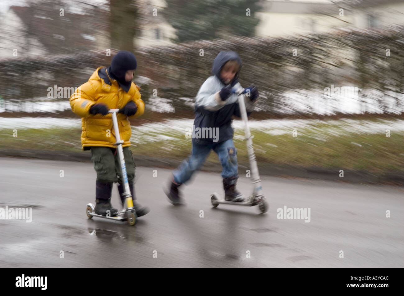 MR Two boys on scooters in winter Stock Photo - Alamy
