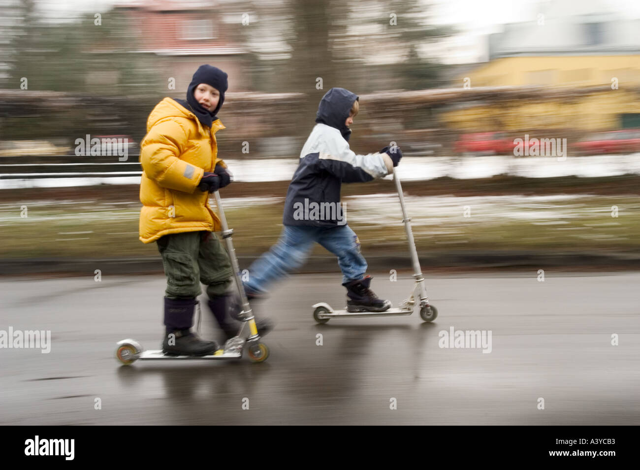 MR Two boys on scooters in winter Stock Photo - Alamy