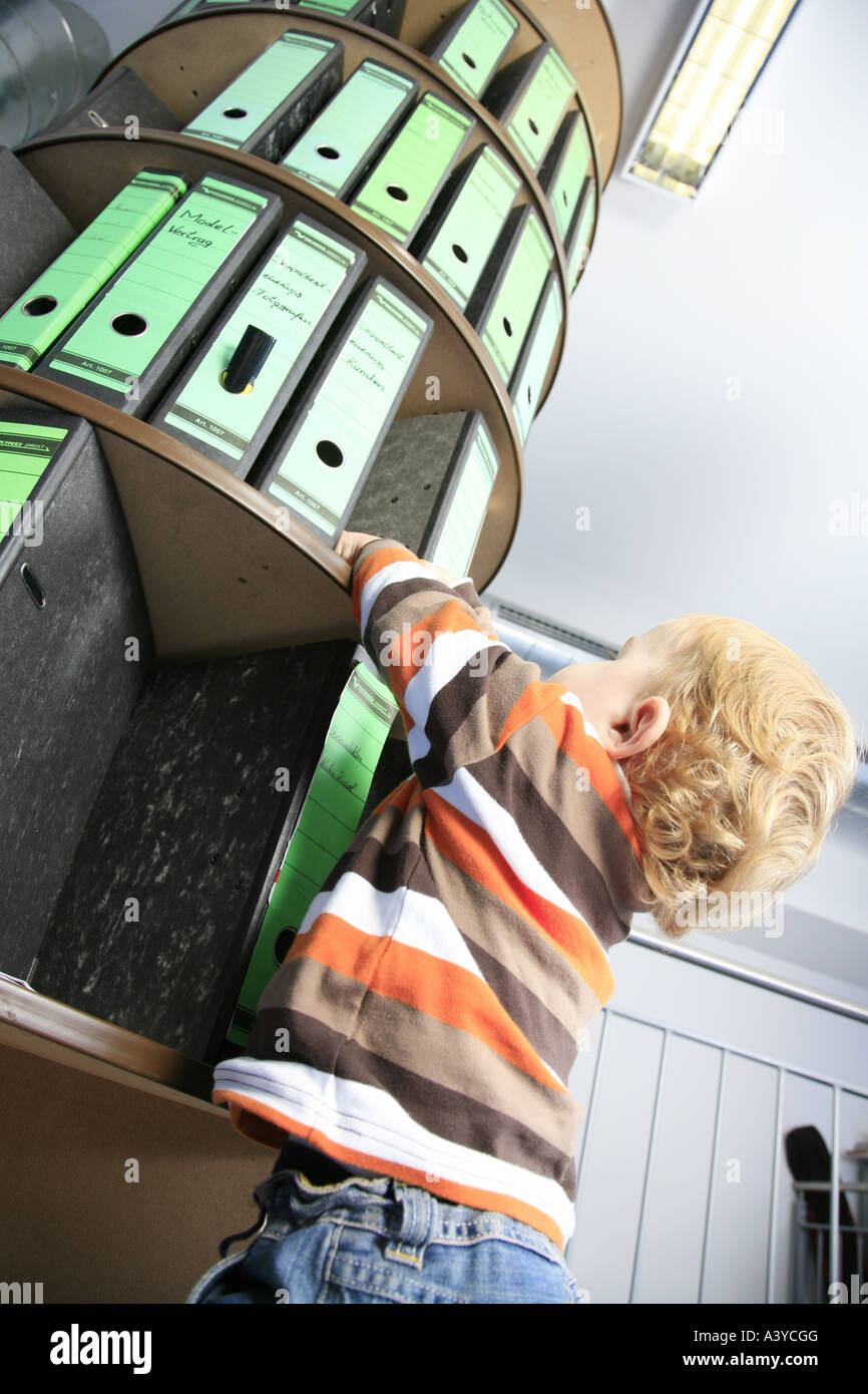small boy in front of a folder storage rack in the office Stock Photo ...