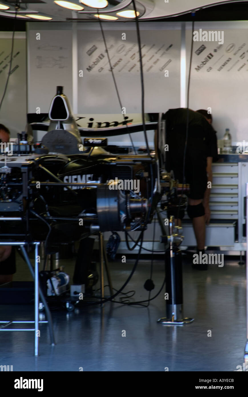 Formula 1 racing car pit lane inside garage mechanics working Gilles ...