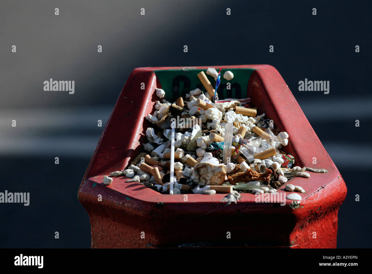 A ashtray full of cigarette ends and chewing gum pictured outside ...
