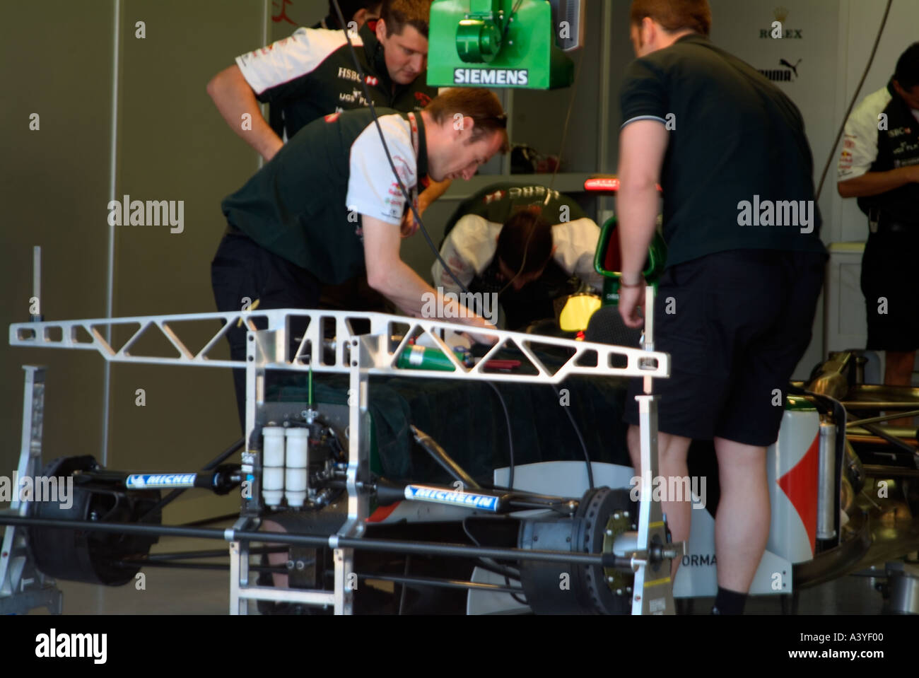 Formula 1 racing car pit lane inside garage mechanics working Gilles ...