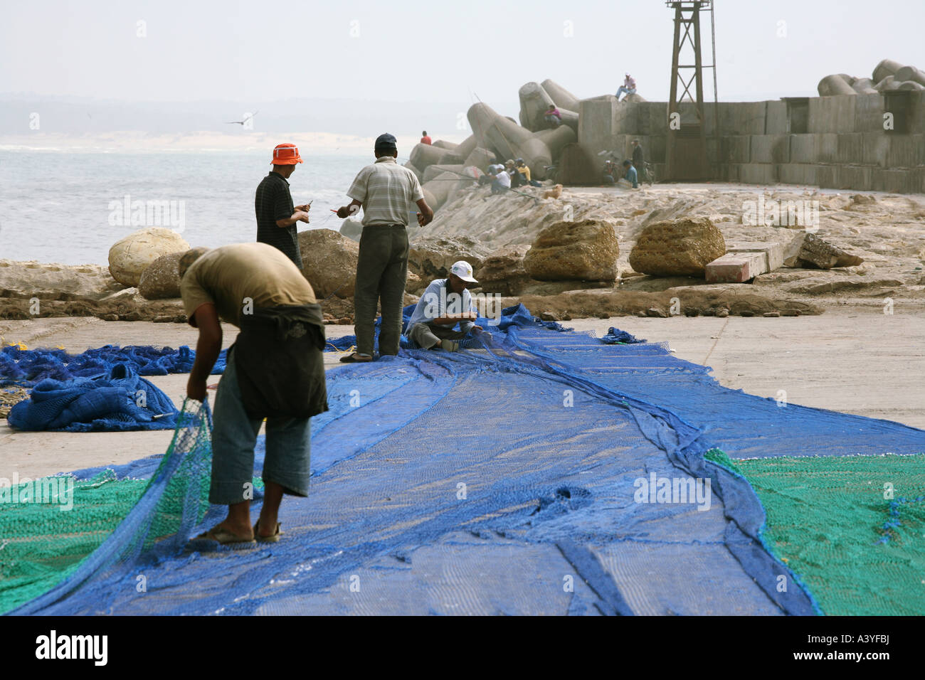 Fishermen repairing their nets Stock Photo - Alamy