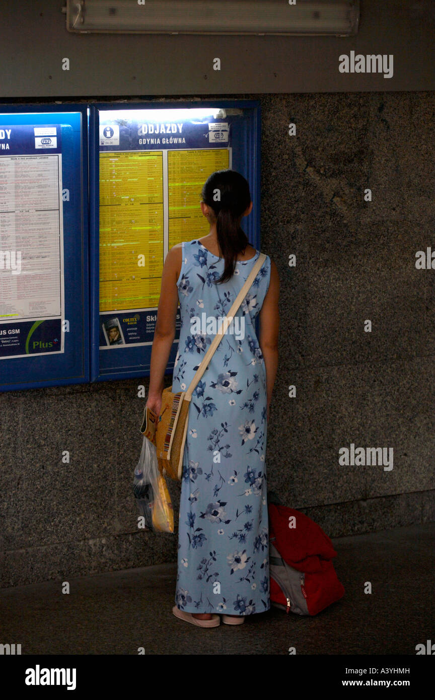 Woman reading a timetable in the underpass of a station Stock Photo - Alamy