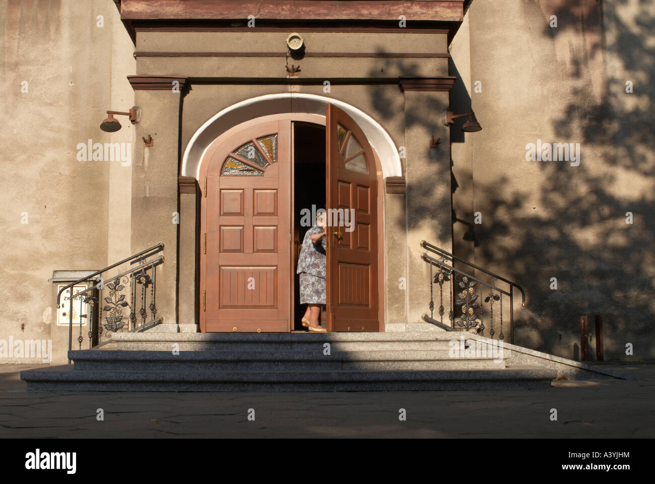 Mature woman entering a building Stock Photo - Alamy