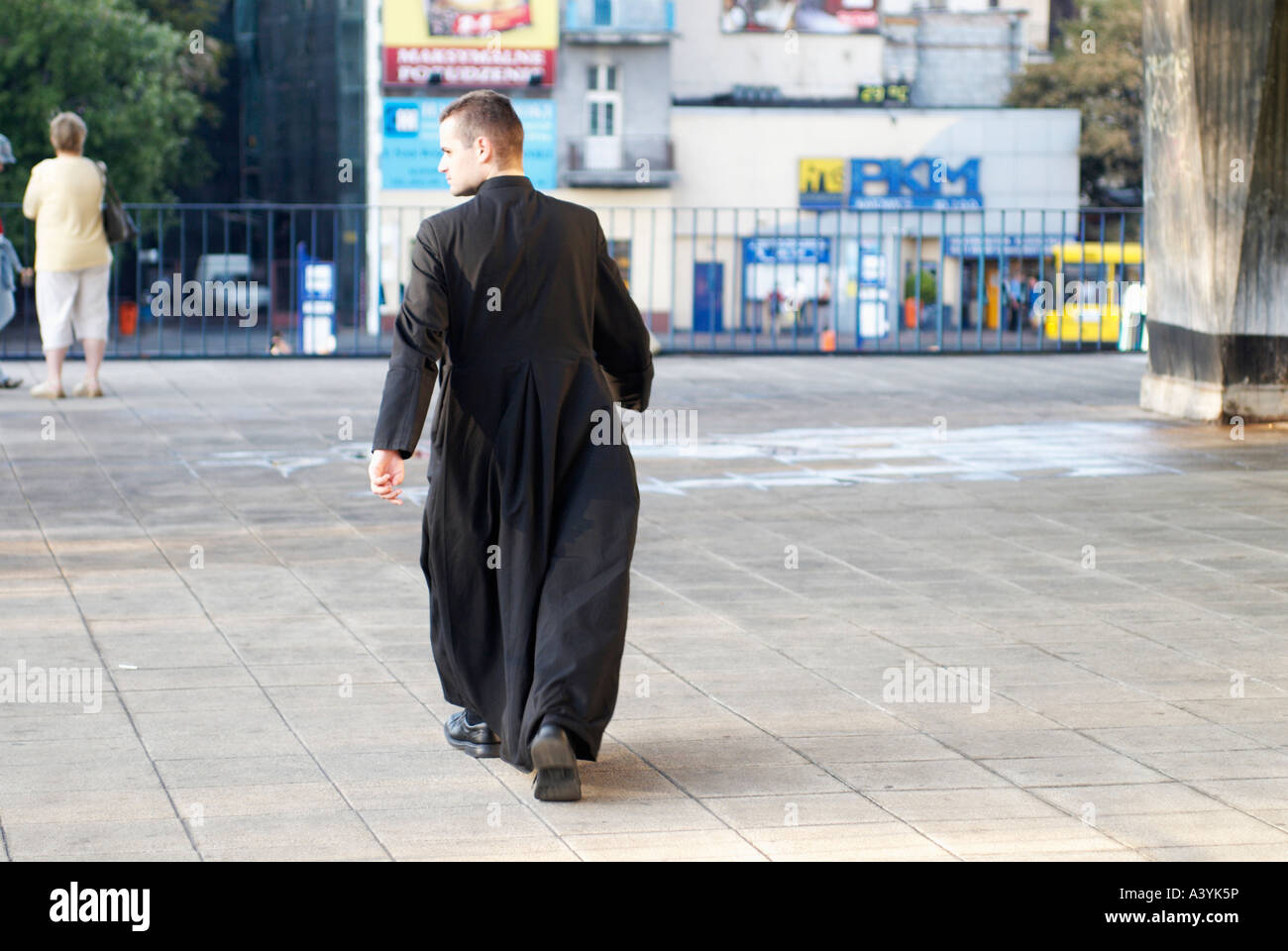 A young priest walking in a town in Poland Stock Photo - Alamy
