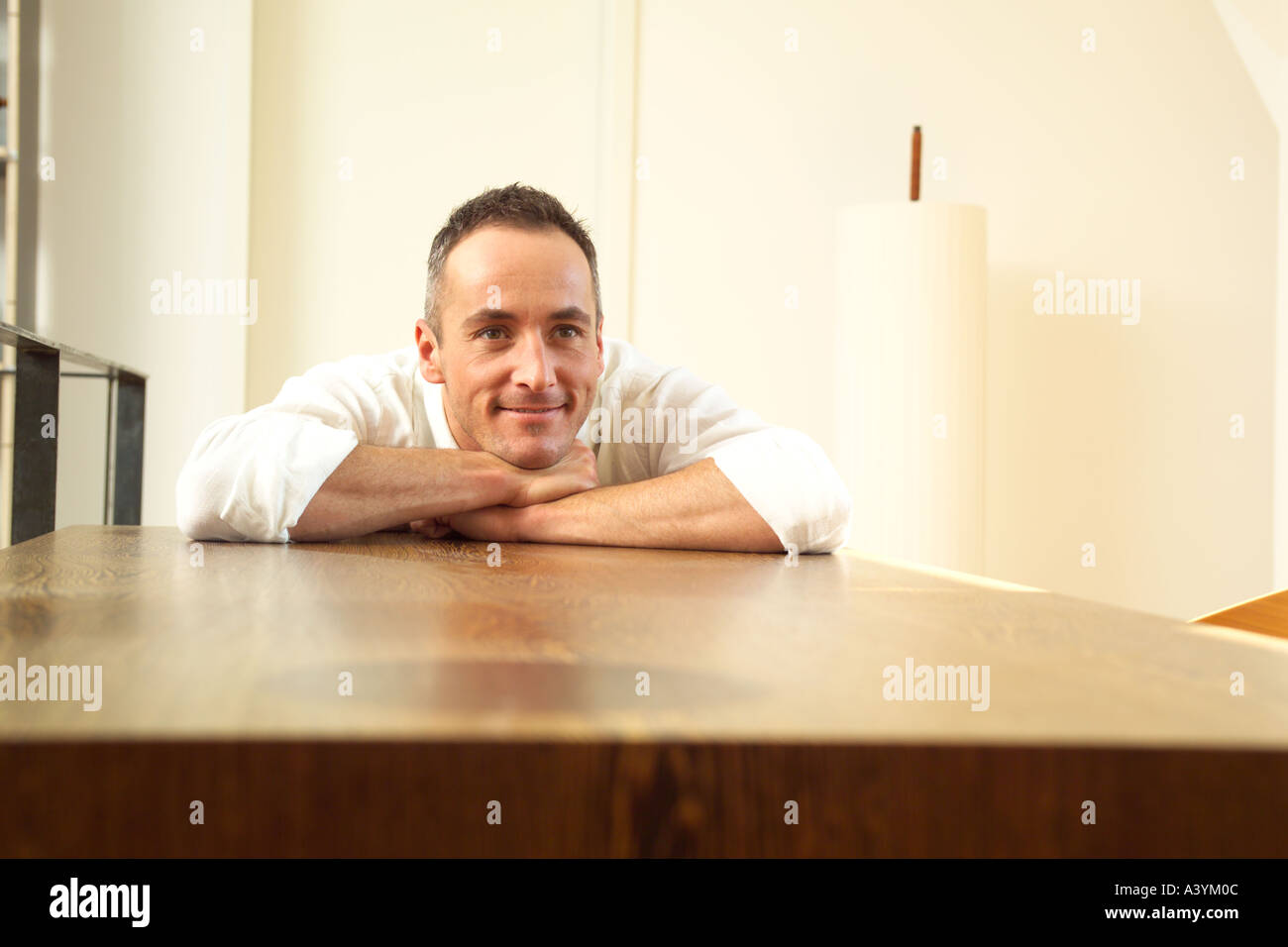 portrait of young man resting his arms on a table Stock Photo - Alamy