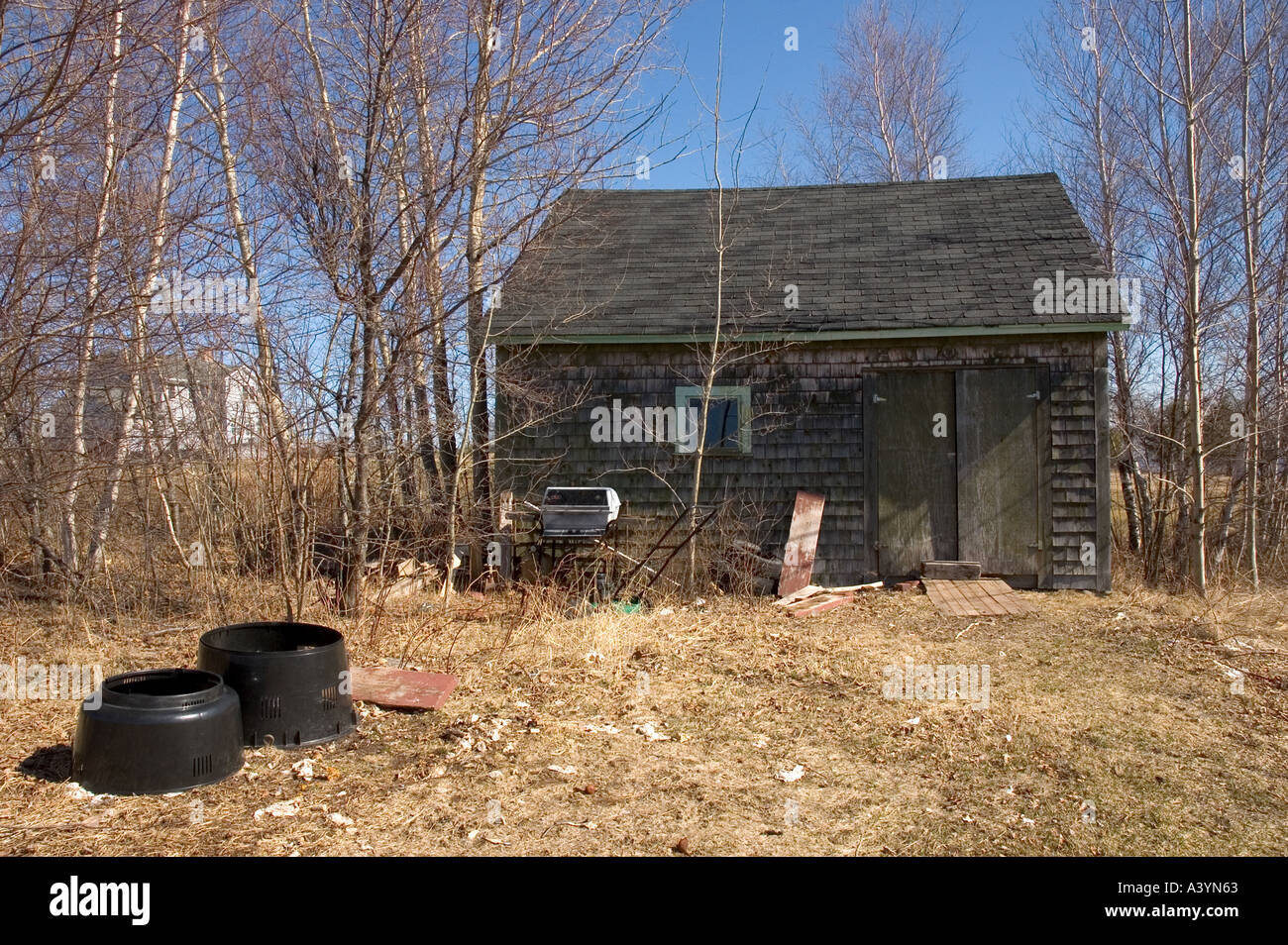 Old shack used for storage with burning barrels in foreground and bare ...