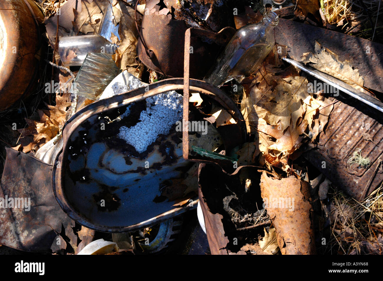 A pile of rusting metal glass and plastic thrown out in the woods ...