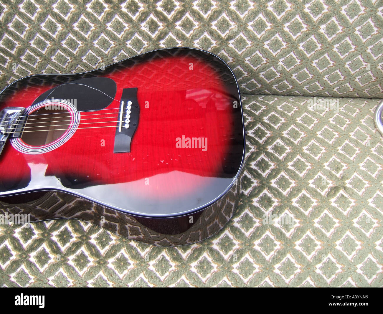 guitar resting on sofa chair Stock Photo - Alamy