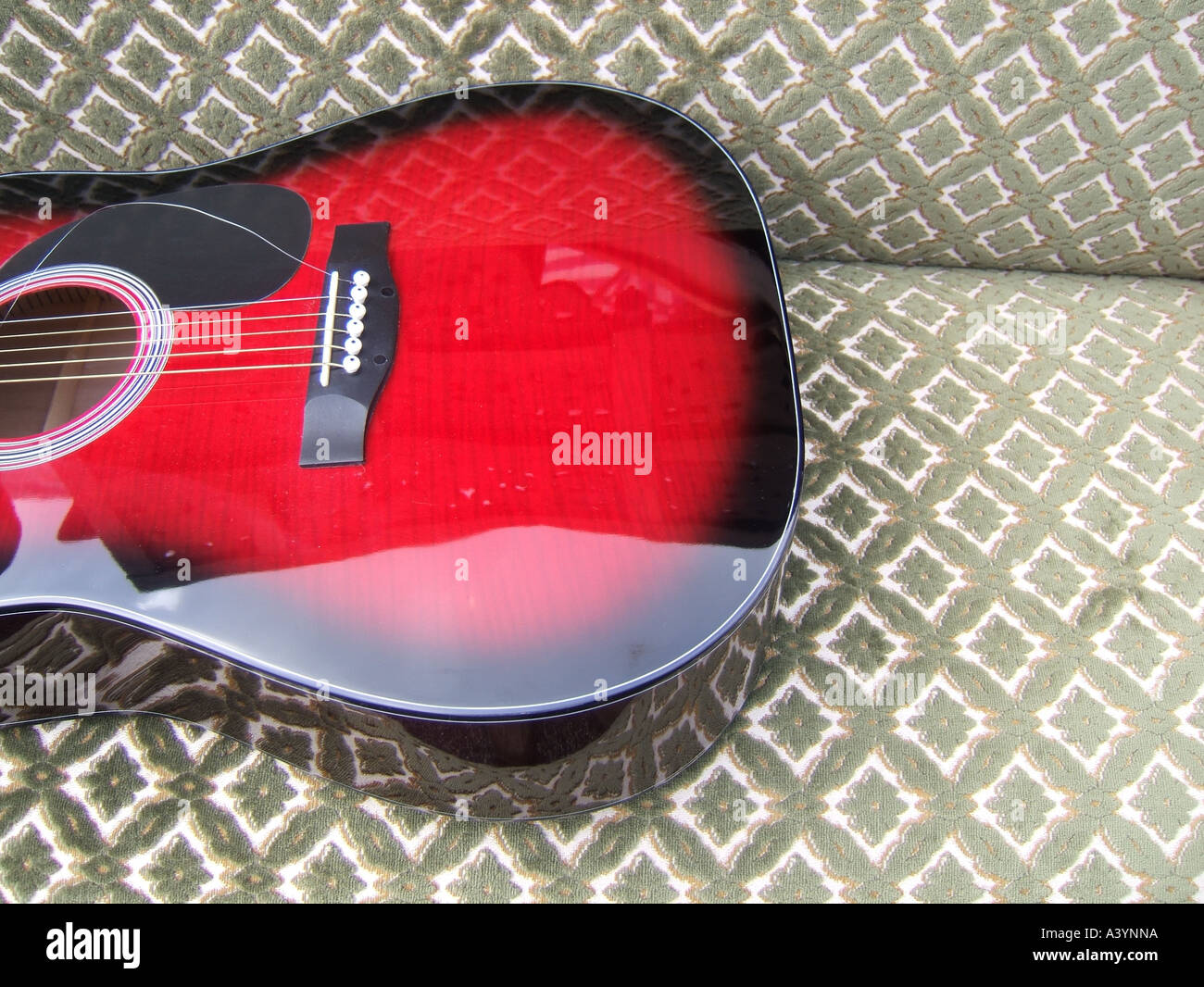 guitar resting on sofa chair Stock Photo - Alamy