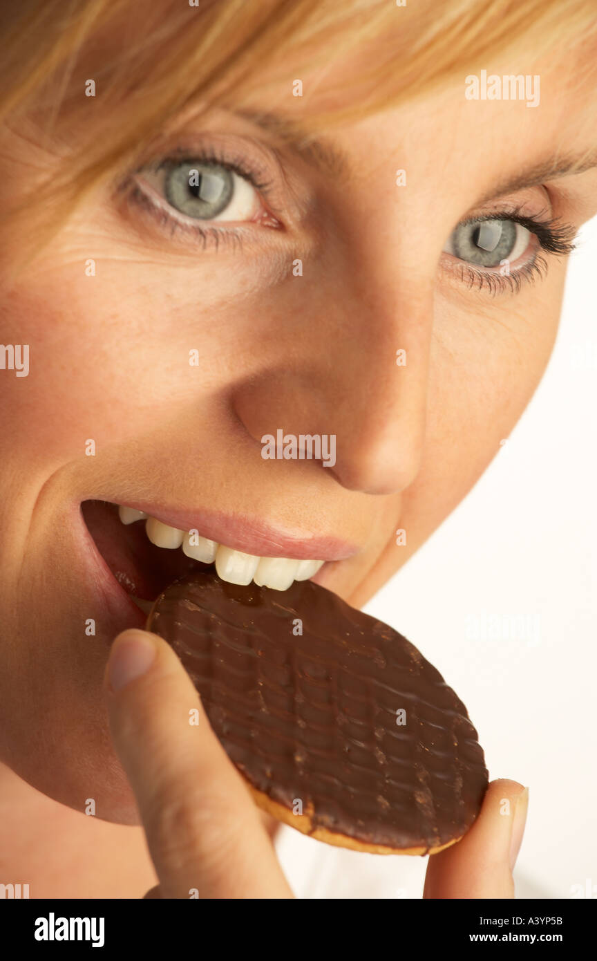 ATTRACTIVE HEALTHY YOUNG WOMAN BITING INTO CHOCOLATE BISCUIT Stock ...