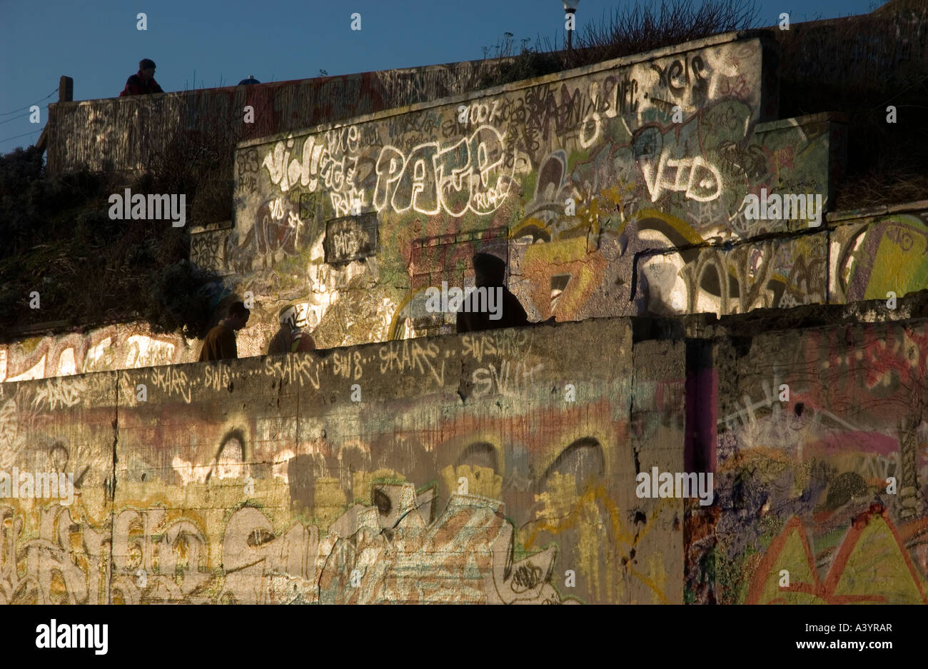 Two young men painting graffiti on a wall in Brighton, Sussex, England ...