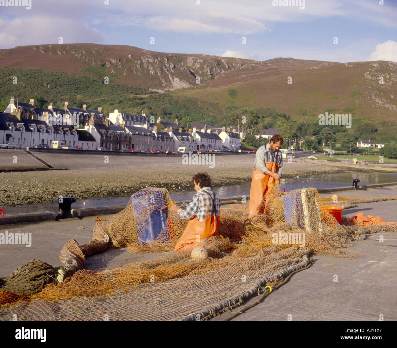 Net mending on Ullapool Pier Stock Photo - Alamy