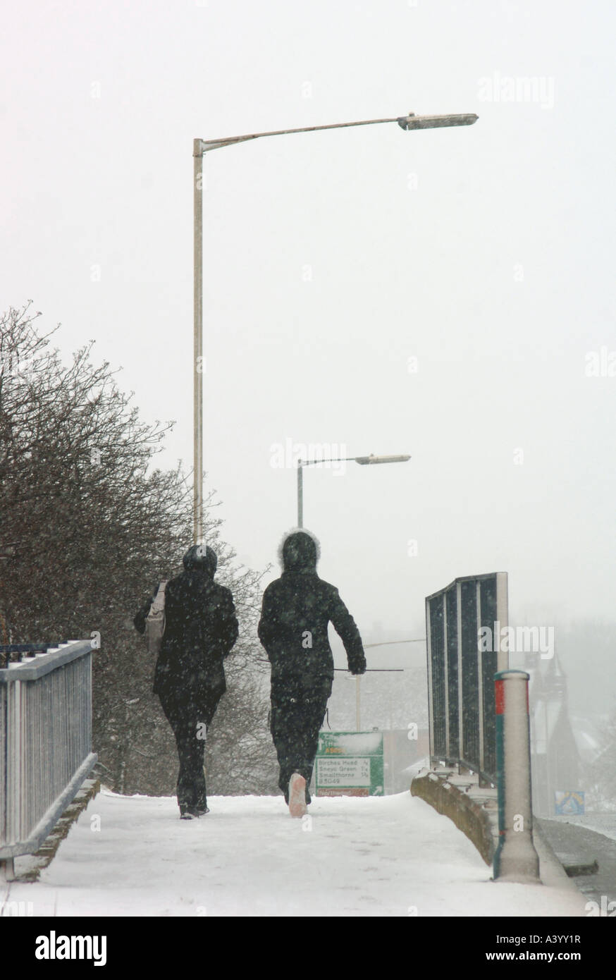 A Couple Of Young Women ,Walking Up A Bank During A Snow Storm Stock ...