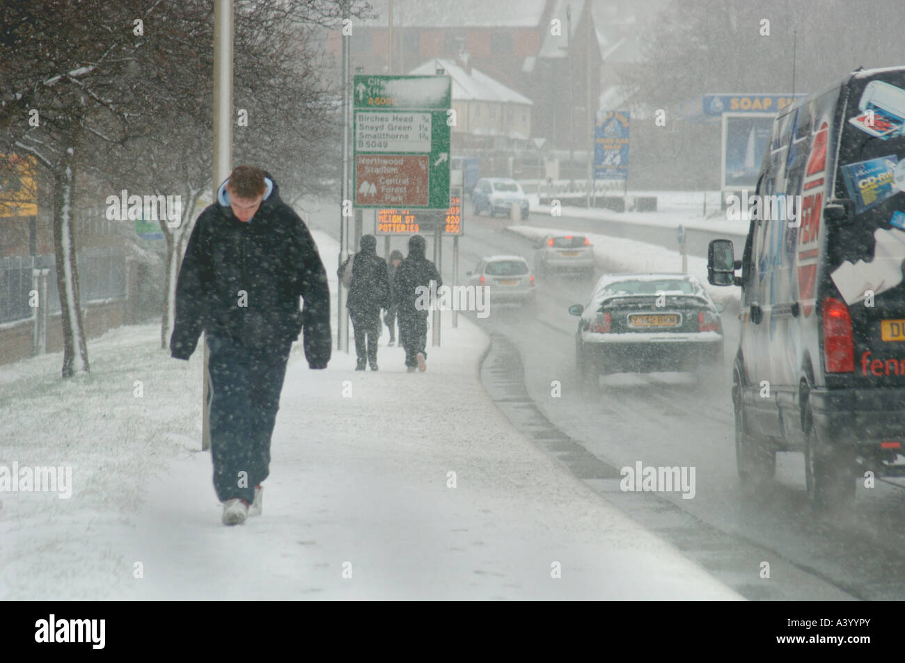 People Walking ThroughA Snow Storm ,Next To Busy Road Filled With ...