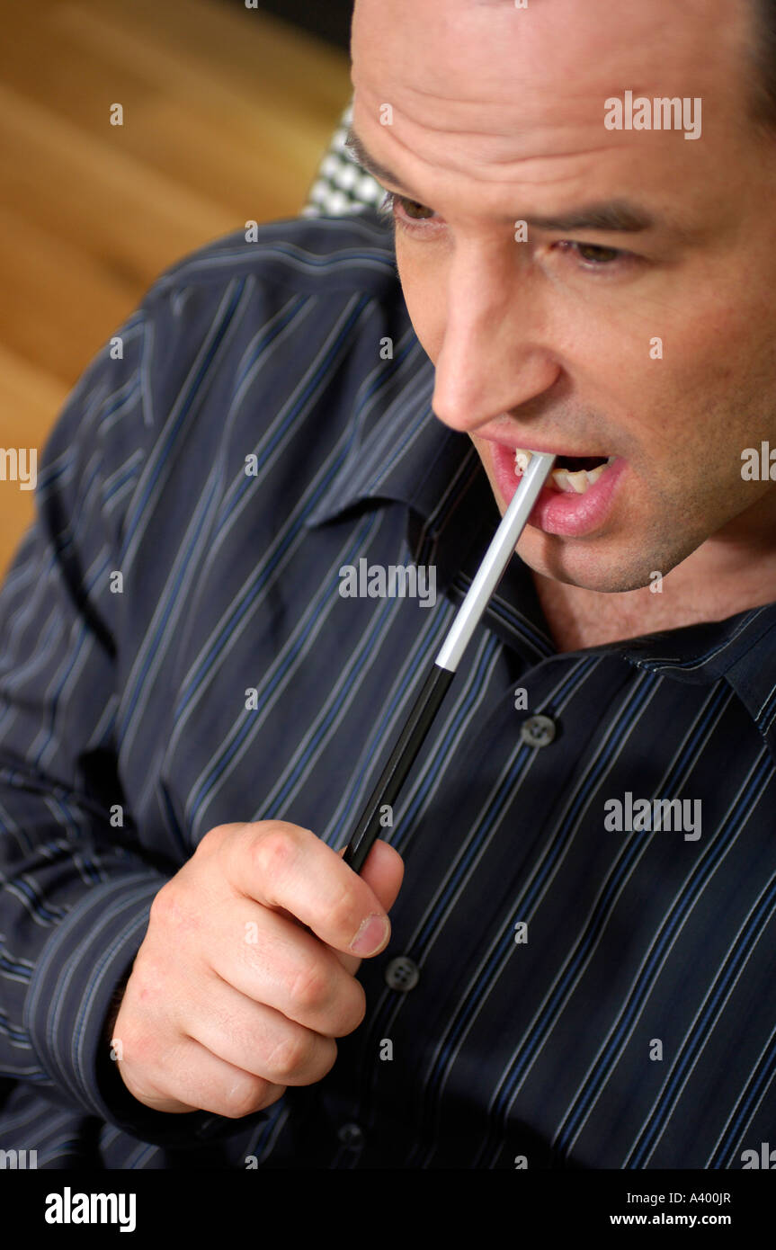 headshot of young businessman holding pen and thinking Stock Photo - Alamy